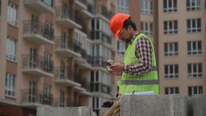 Construction Industry Worker Texting during Lunch Break. Helmeted ...