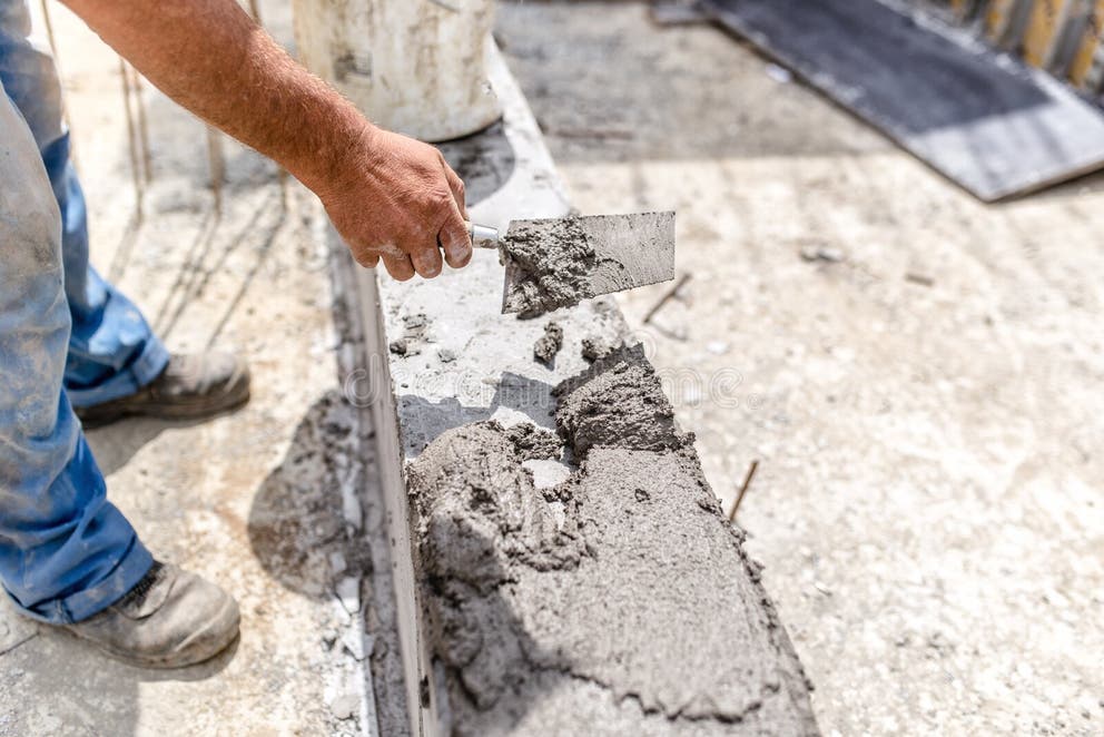 Construction Industry Worker Using a Putty Knife and Leveling Concrete ...