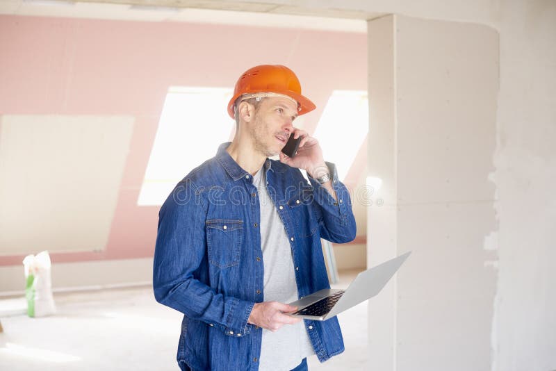 Construction Worker Using Laptop and Mobile Phone Stock Photo - Image ...