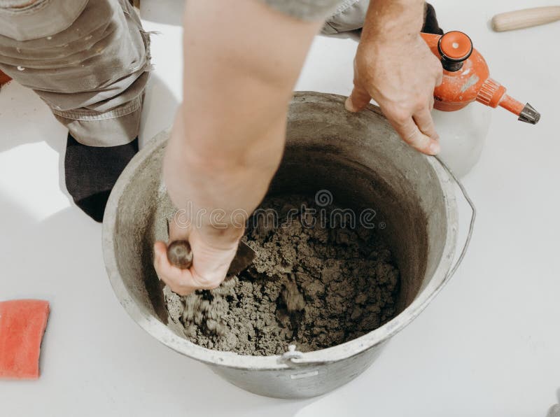 A Construction Man Mixes a Cement Solution in a Bucket. Stock Photo ...
