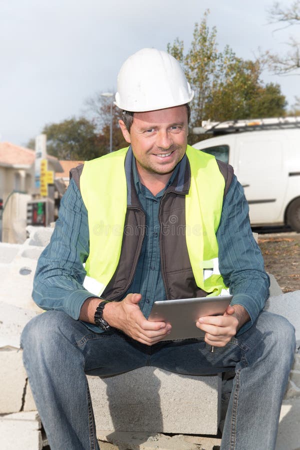 Construction Man Worker Looking in Tablet Computer Pad while Sitting ...