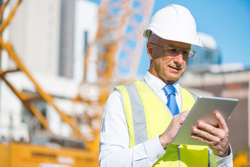 Construction Manager Controlling Building Site and Tablet Device in His ...
