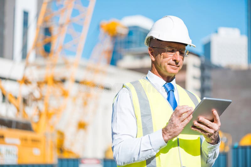 Construction Manager Controlling Building Site and Tablet Device in His ...
