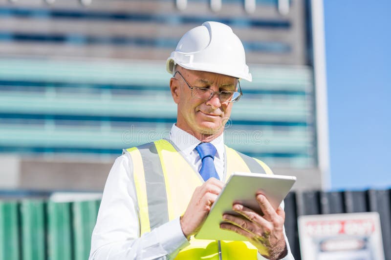 Construction Manager Controlling Building Site and Tablet Device in His ...