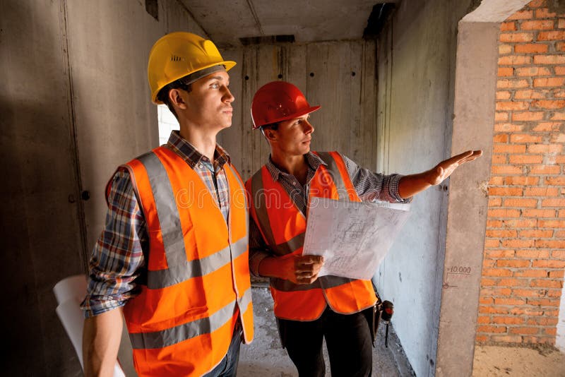 Construction Manager and Engineer Dressed in Orange Work Vests and ...