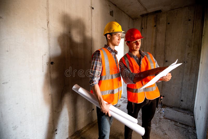 Construction Manager and Engineer Dressed in Orange Work Vests and ...