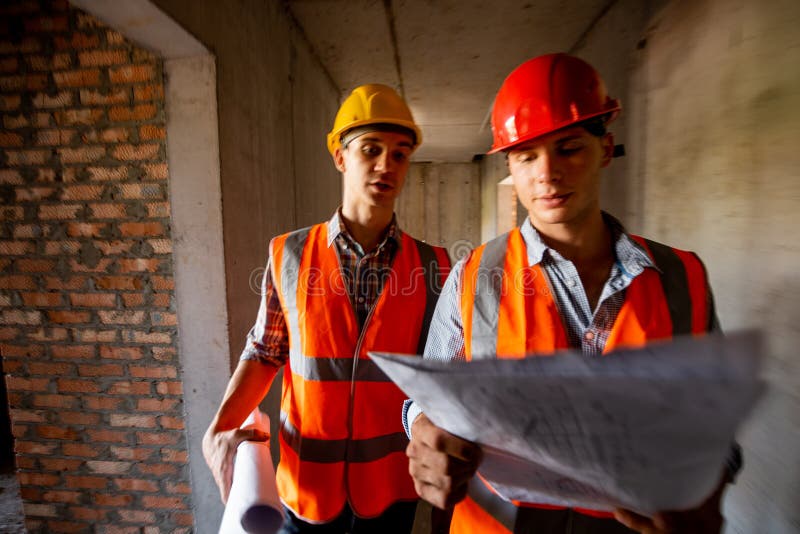 Construction Manager and Engineer Dressed in Orange Work Vests and ...
