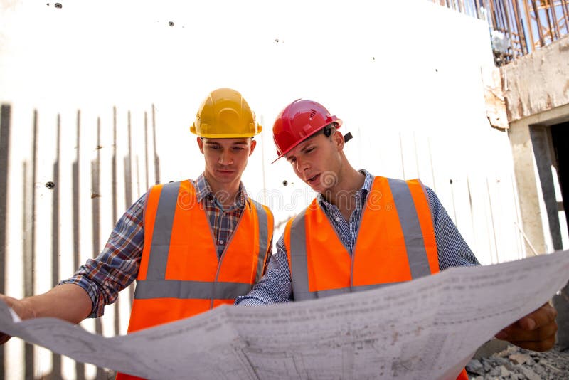 Construction Manager and Engineer Dressed in Work Clothes and Hard Hats ...