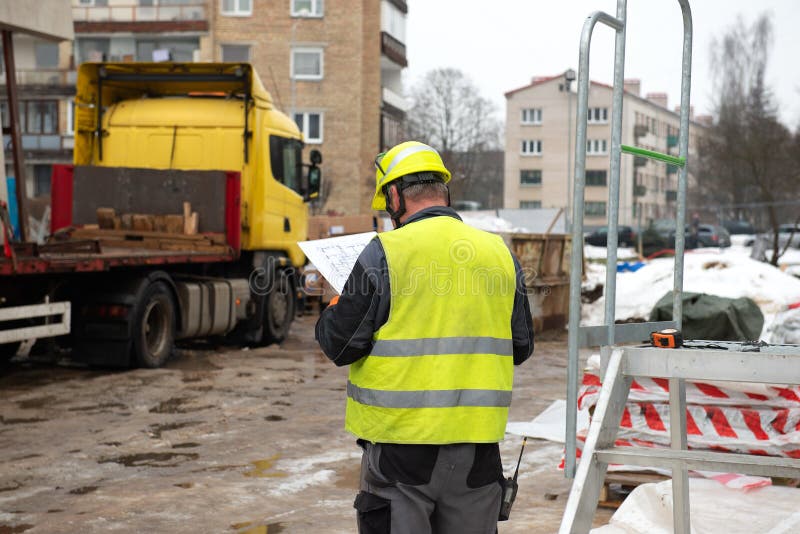 The Construction Manager Looks at the Drawing Design while Standing on ...