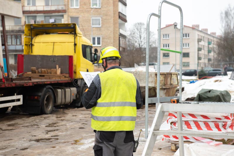 The Construction Manager Looks at the Drawing Design while Standing on ...
