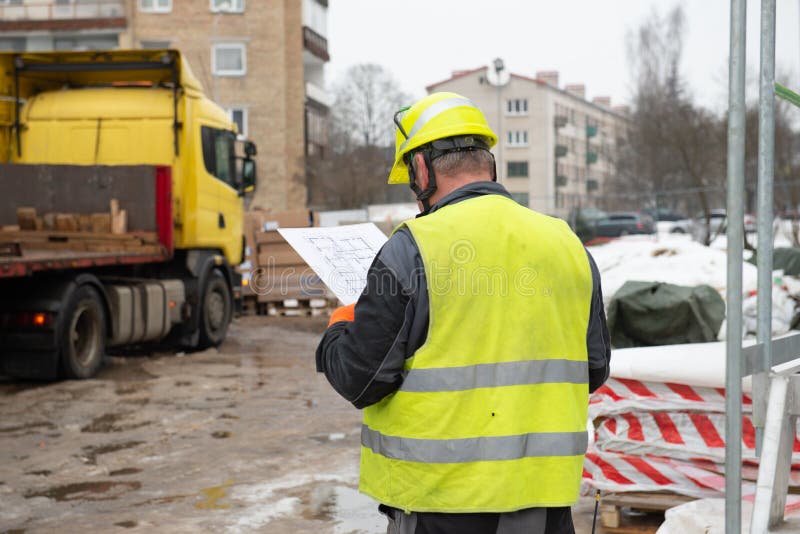 The Construction Manager Looks at the Drawing Design while Standing on ...