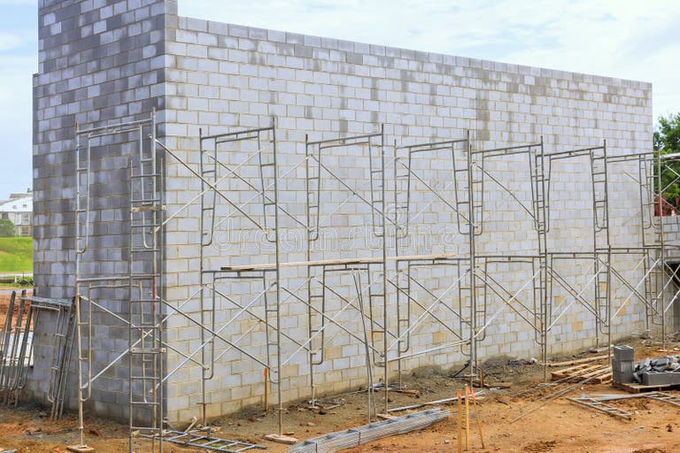 During Construction, Mason Makes Concrete Wall from Cement Blocks while Standing on a Scaffold ...