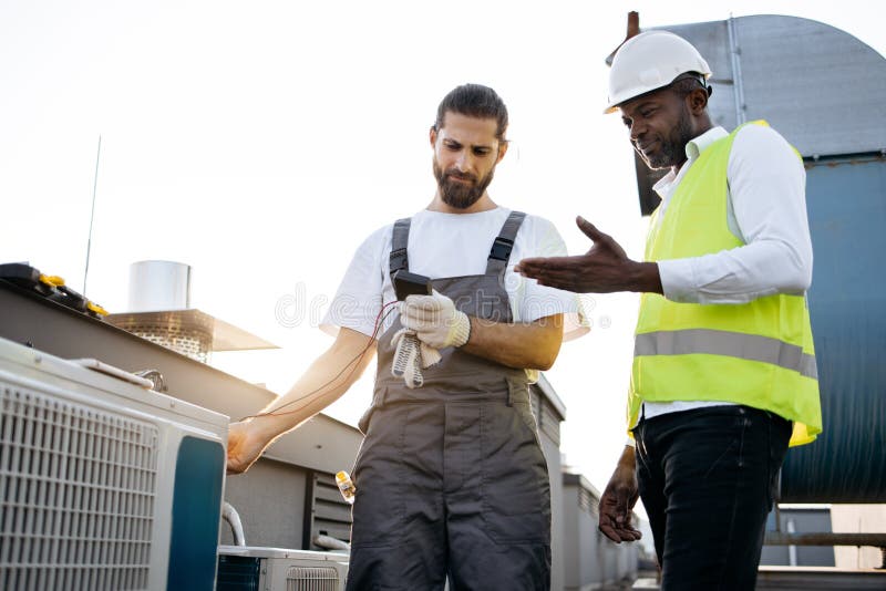 Construction Men Using Multimeter for Conditioner on Rooftop Stock ...
