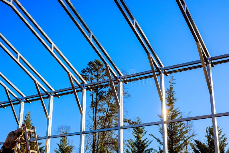 Construction of a Metal Framework Under a Clear Blue Sky with Trees in ...