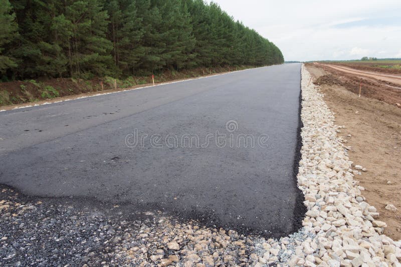 Construction of a New Road. Fresh Asphalt Laying. the Beginning of the ...