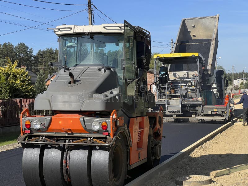 Construction of a New Street Surface. Laying a Layer of Asphalt with a ...