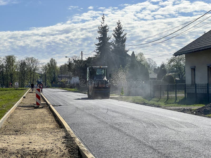Construction of a New Street Surface. Laying a Layer of Asphalt with a ...