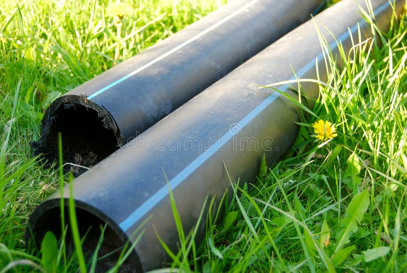 Construction Pipes Lying on the Grass Stock Photo - Image of electrical ...