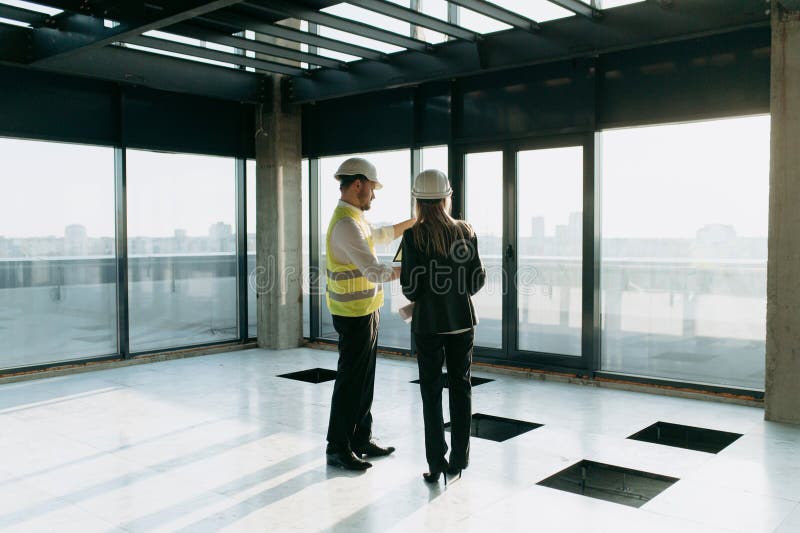 Construction Professionals Discussing Project Details in Modern Interior. Architect or Engineer ...