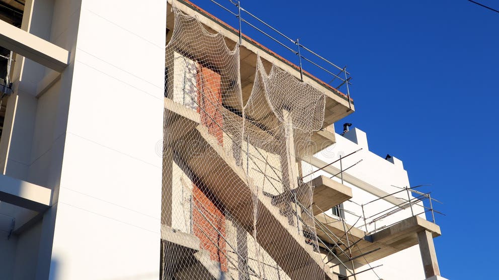 Construction Progress on a Building with Safety Netting and Scaffolding ...