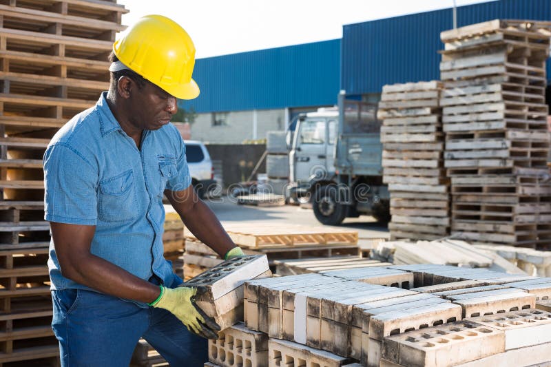 Construction Shop Worker Stacks Bricks on an Open Air Site at Summer ...