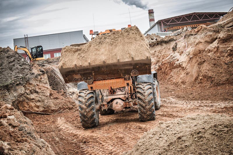 Construction Site Activity Featuring a Dump Truck Unloading Dirt at an ...