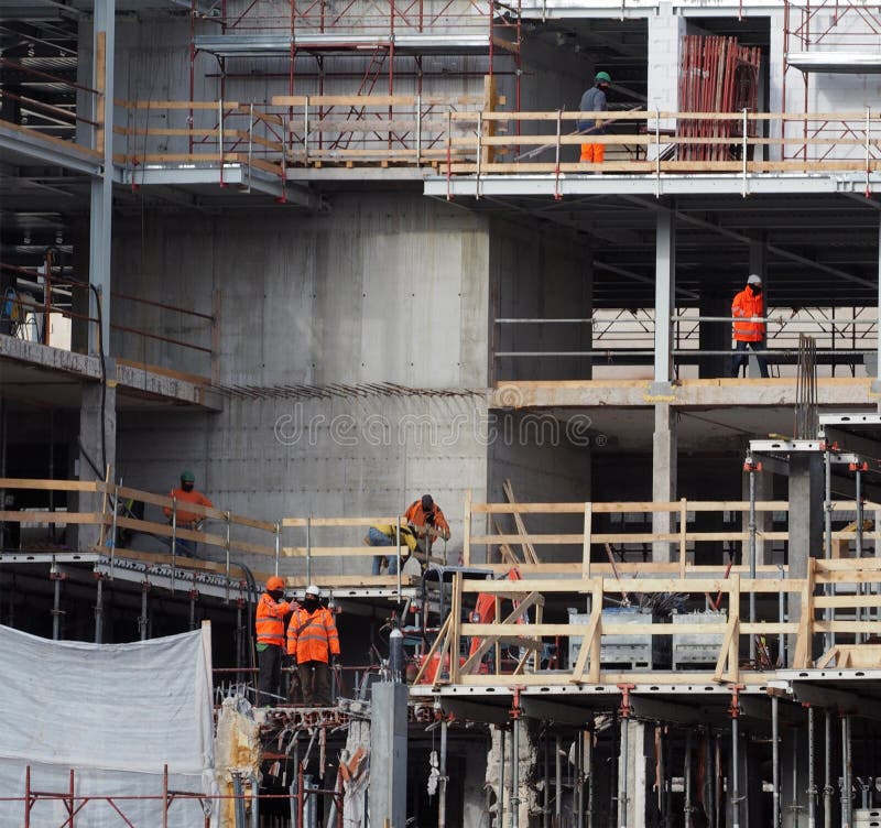 Construction Site Activity. Workers with Work Wears in a New Building ...