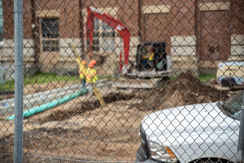 Construction Site Behind the Fence Workers are Working. Stock Photo ...