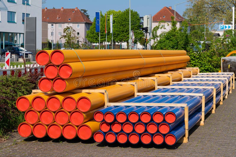 Construction Site. Stack of Orange-yellow and Blue PVC Conduit Pipes ...