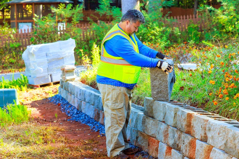 On a Construction Site Construction Worker Installs Concrete Blocks To ...