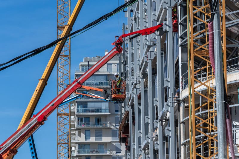 Construction Site with Cranes and Workers on a High-rise Building ...