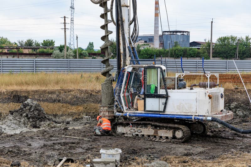 Construction Site: Drilling Rig and Worker Operating Heavy Equipment ...