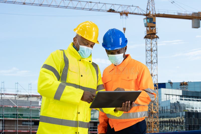 Site Engineer with a Safety Equipment Walking and Carrying Blueprints ...