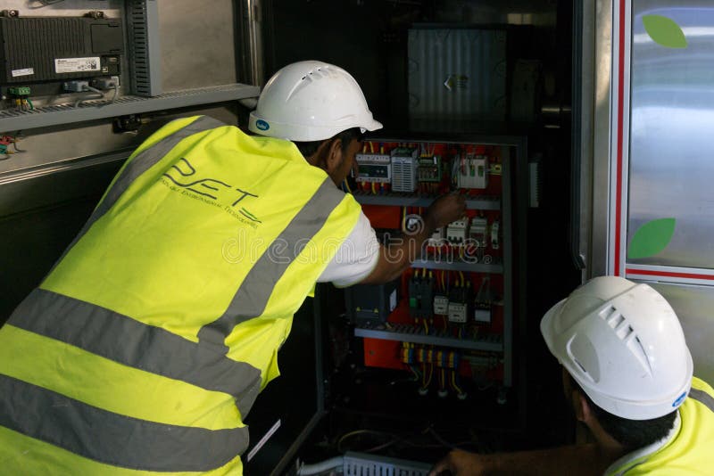 Construction Site with Engineers and Workers Fixing a Machine in a ...