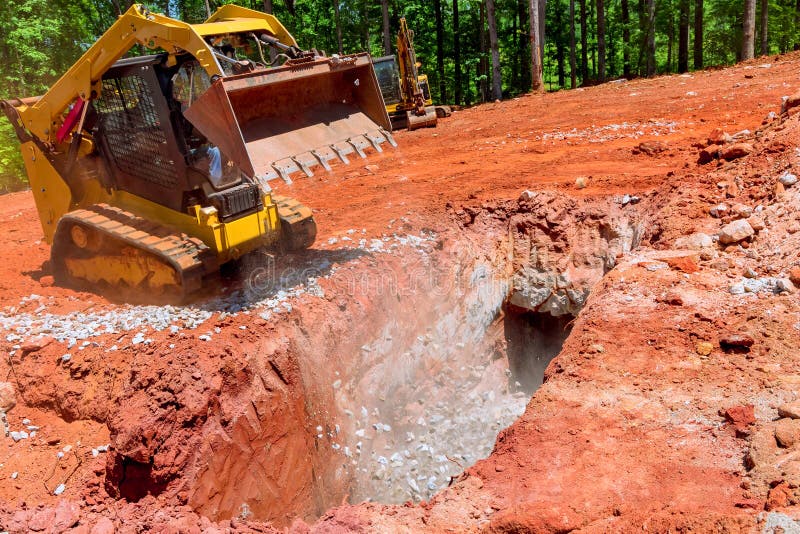 At a Construction Site, an Excavator Bucket Skid Steer Loader is ...