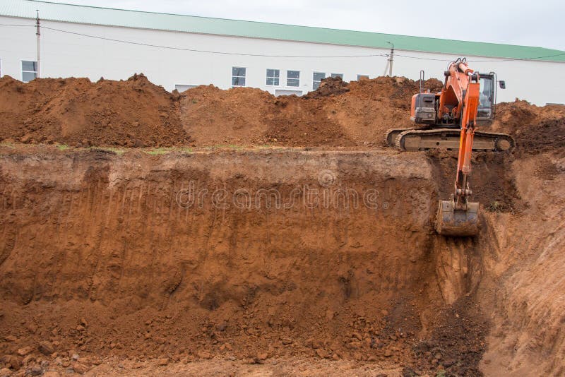 The Construction Site Excavator Digs a Deep Pit. Digger. Construction ...