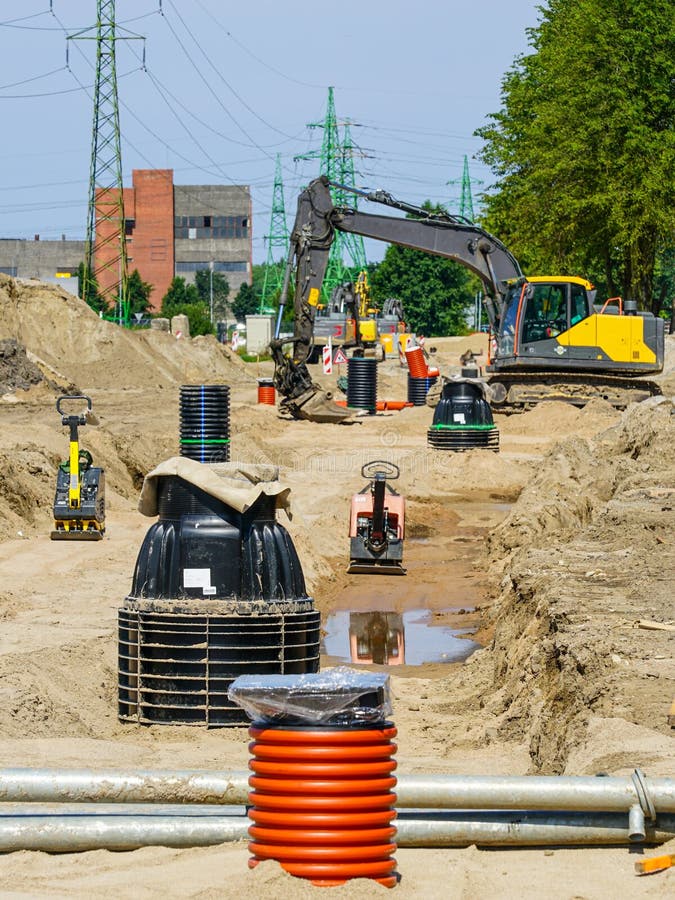 Excavator and Utility Installation at Construction Site with Pipes ...