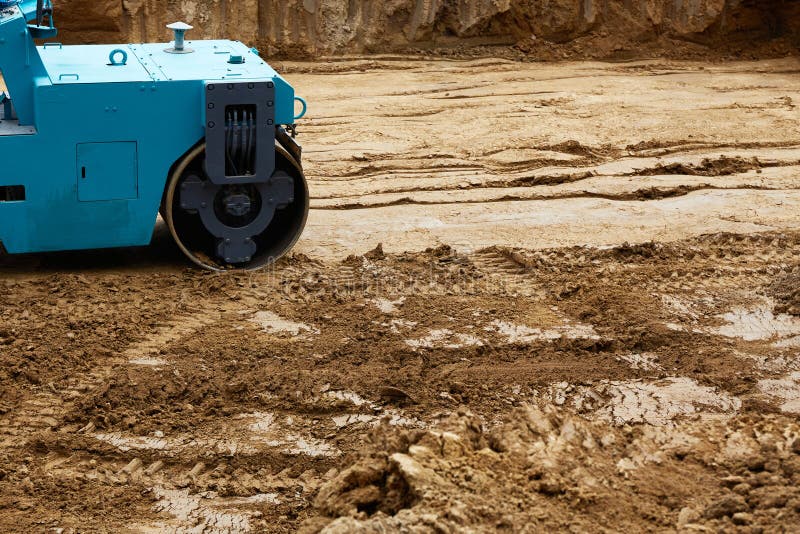 Construction Site Features a Blue Roller Compacting Earth on a Freshly ...