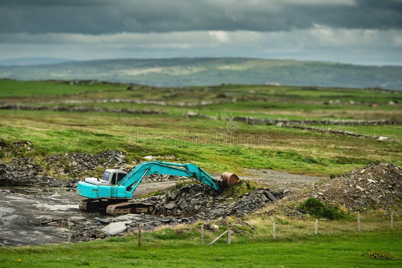 Construction Site in a Field with Blue Color Excavator Working. Dark ...