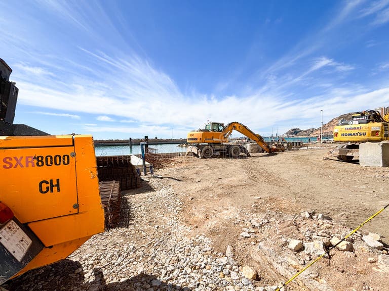 Construction Site with Heavy Machinery Operating Under a Bright Blue ...