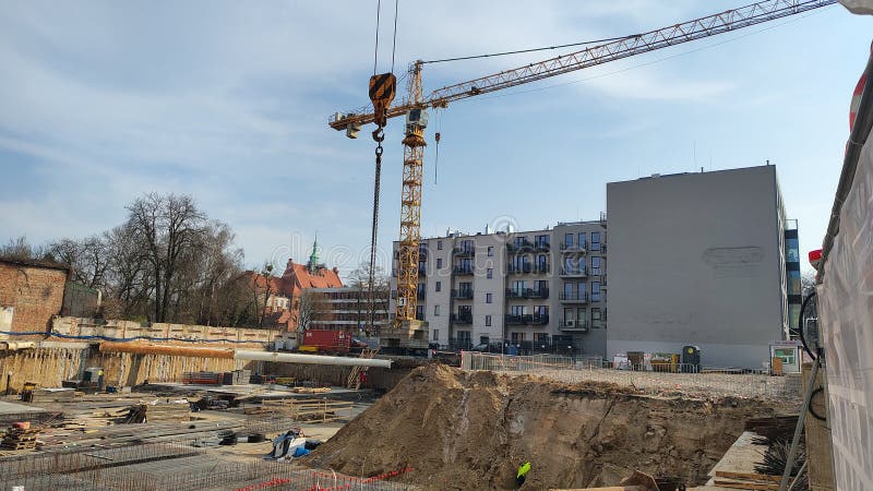 Construction Site with a Large Crane, Foundation Work, and Surrounding Modern Buildings Under ...