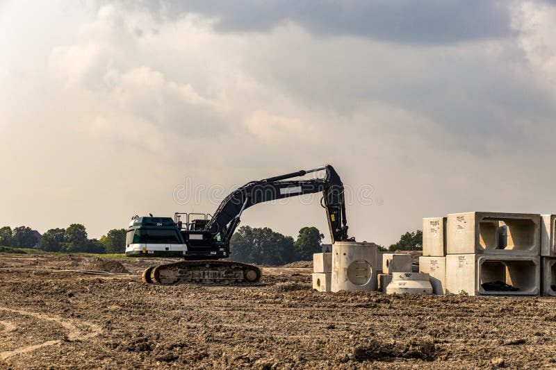 A Construction Site with a Large Excavator Digging and a Partially ...