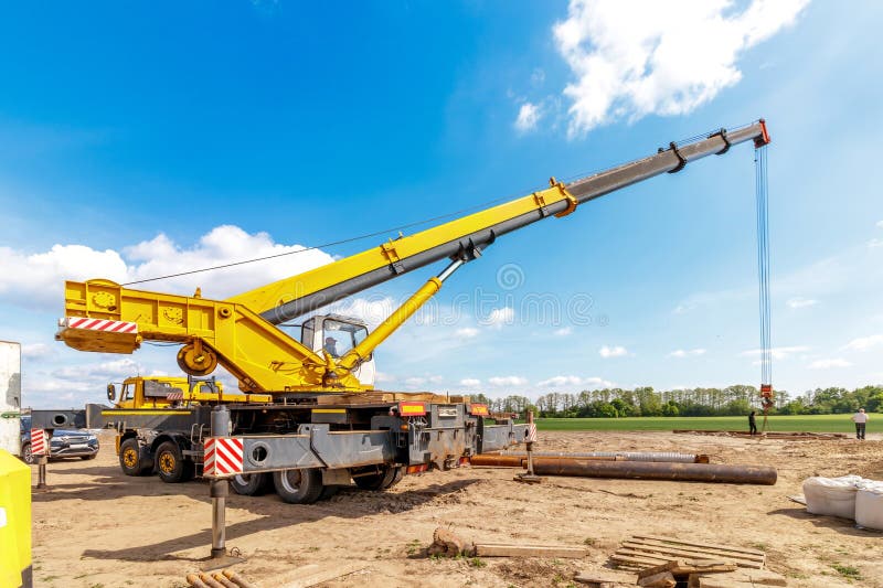 A Construction Site with a Lifting Crane and Workers Installing Water ...