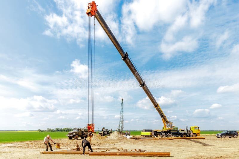 A Construction Site with a Lifting Crane and Workers Installing Water ...