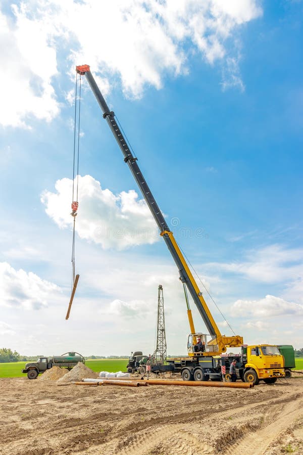 A Construction Site with a Lifting Crane and Workers Installing Water ...