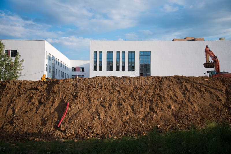 Construction Site. Lots of Dirt, an Excavator and a New White Building ...