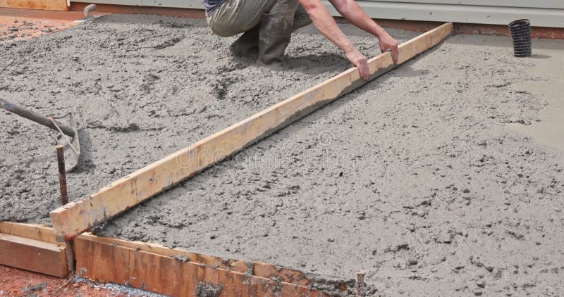 In Construction Site, Mason Levels Screeding Concrete for a Foundation ... In Construction Site, Mason Levels Screeding Concrete for a Foundation ...