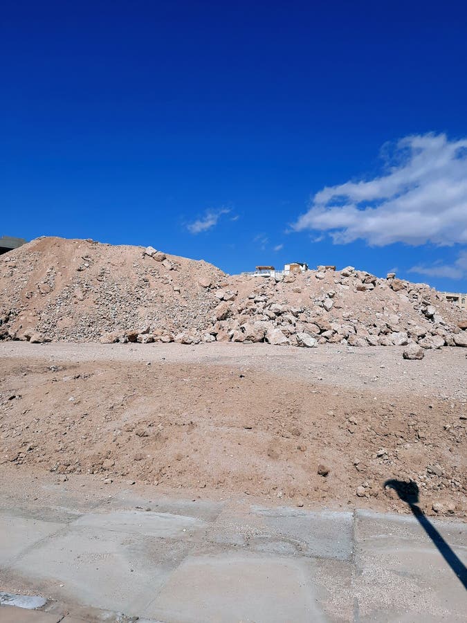 Construction Site with Piles of Sand and Rocks Under a Clear Blue Sky ...