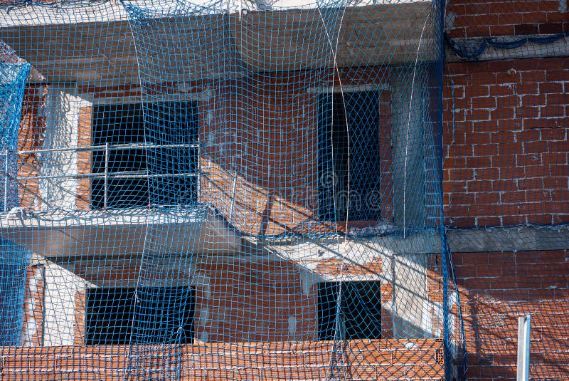 Construction Site with Scaffolding and Protective Netting on Multi ...