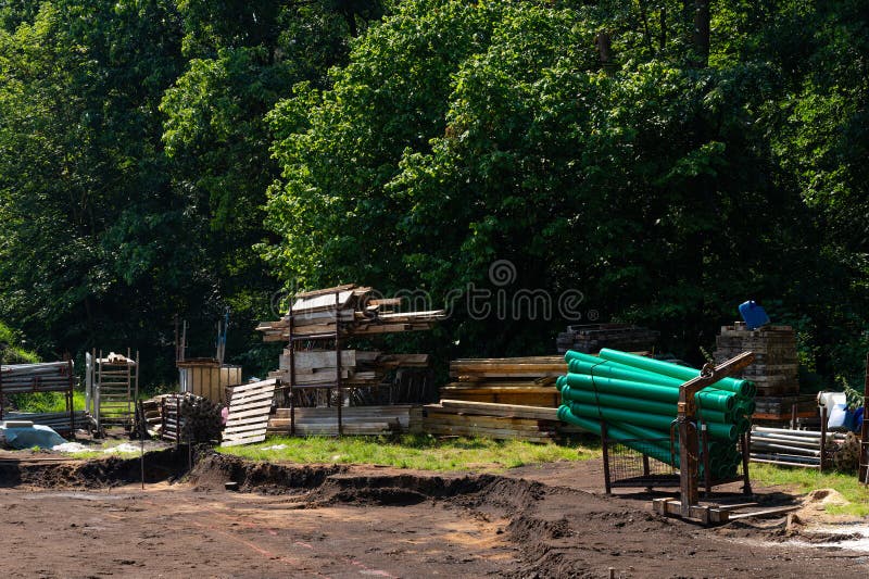 Construction Site with Stacked Materials and Equipment Surrounded by ...